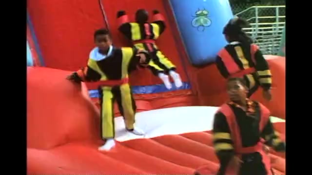 Three black boys jumping on a Velcro trampoline in Hamilton, Bermuda ...
