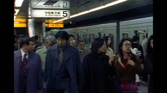 The Tokyo Subway, crowd on platform, wide shot with train, zoom in as ...